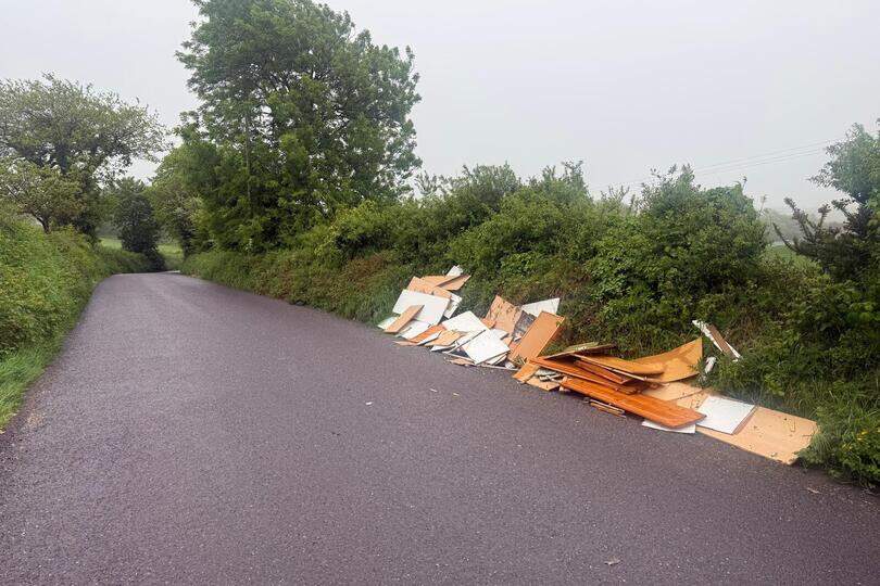 Piles of timber, broken doors and mirrors dumped on country road in ...